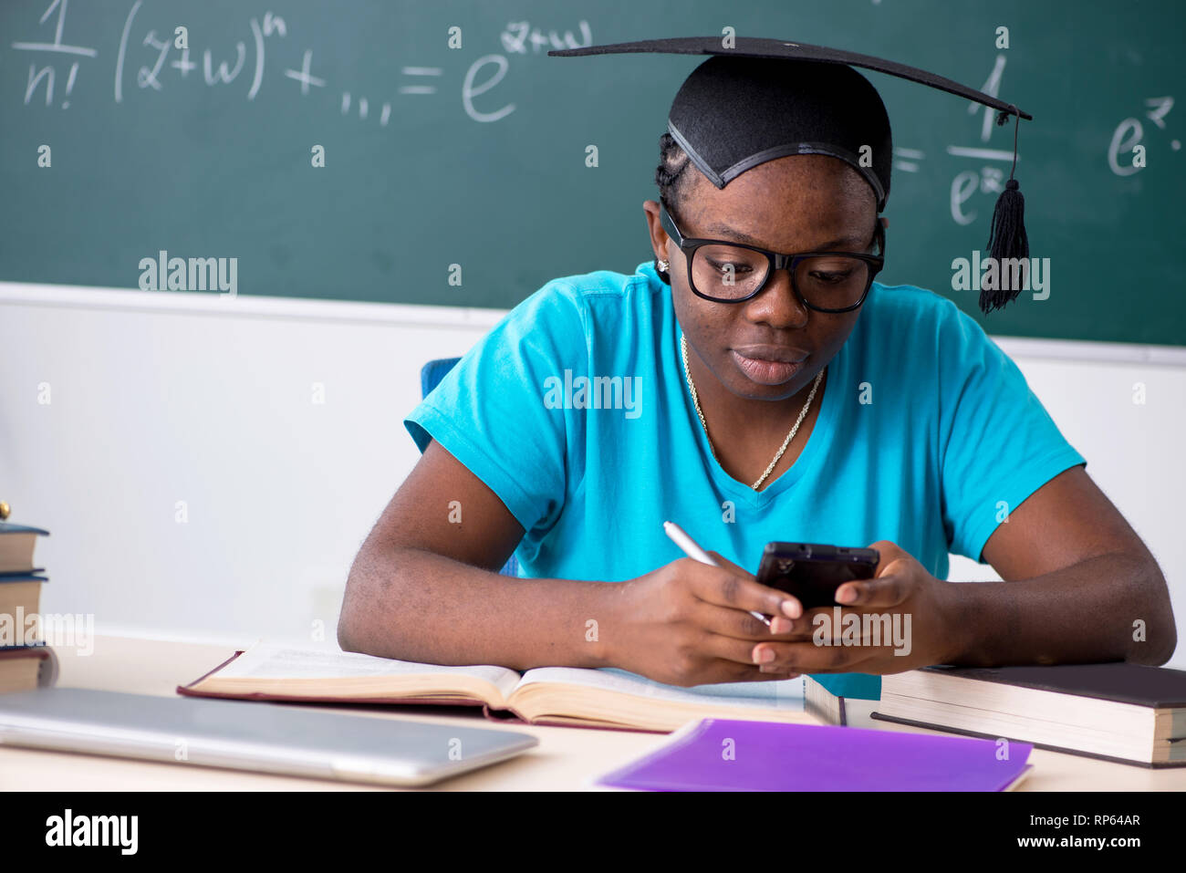 Black female student in front of chalkboard Stock Photo - Alamy