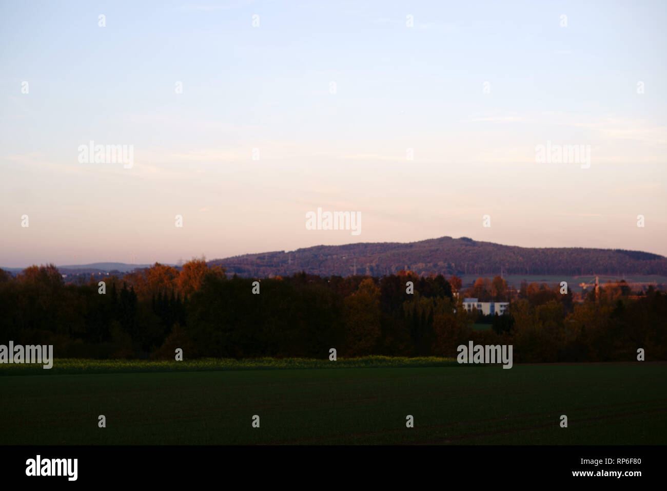 An autumn landscape with fields, meadows, trees and hills during sunset ...