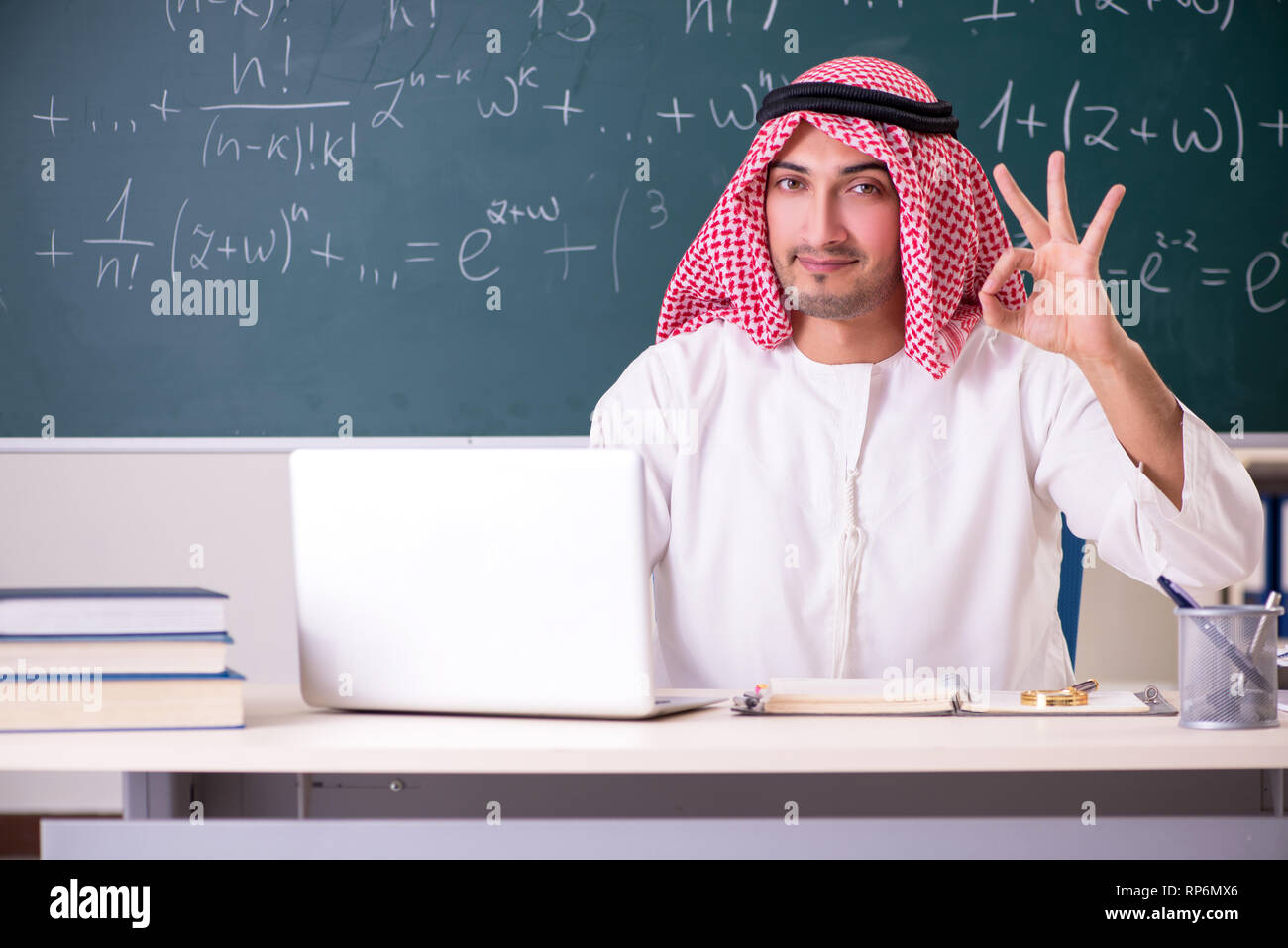 Arab teacher in front of chalkboard Stock Photo - Alamy