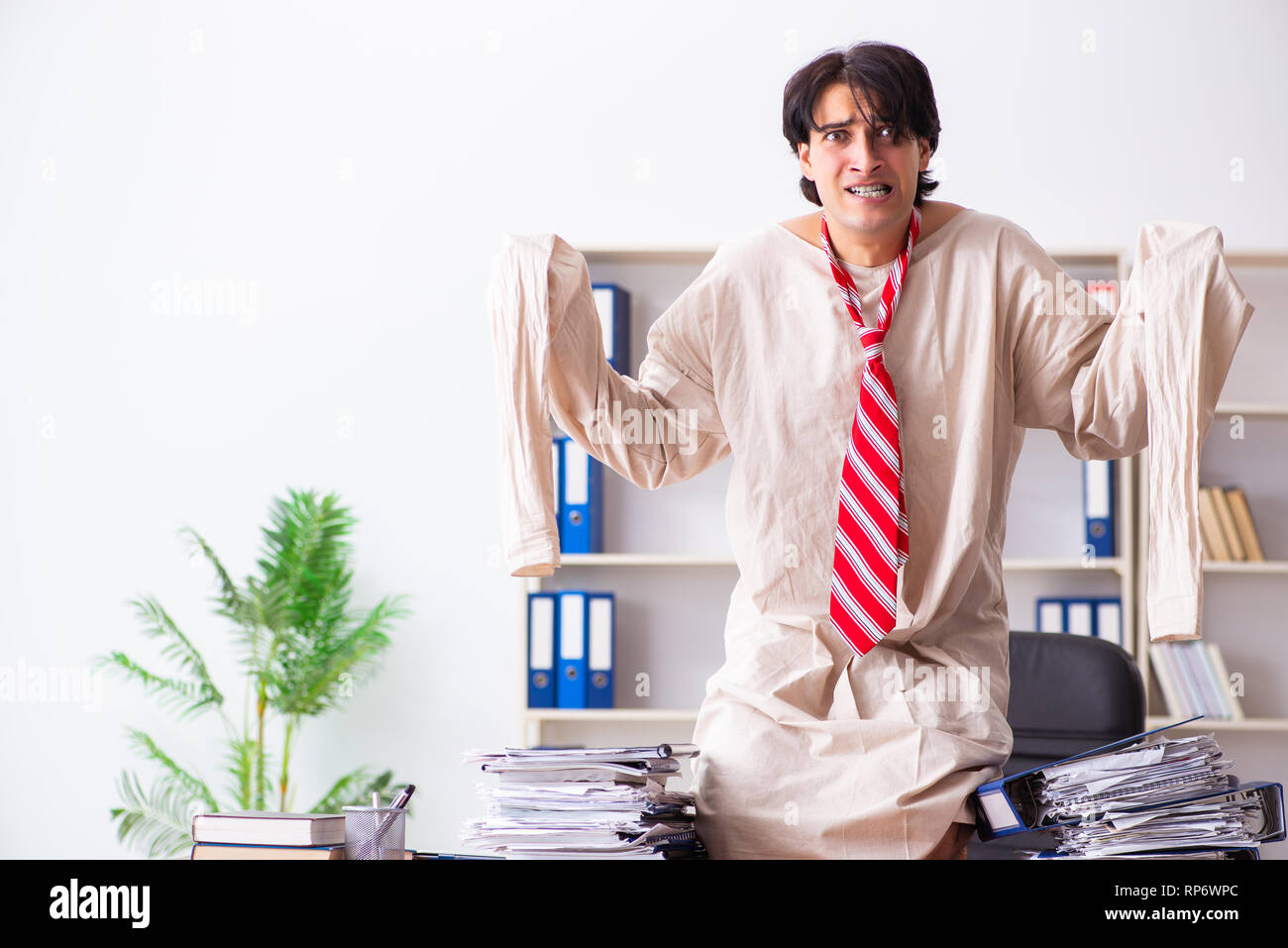 Crazy young man in straitjacket at the office Stock Photo - Alamy