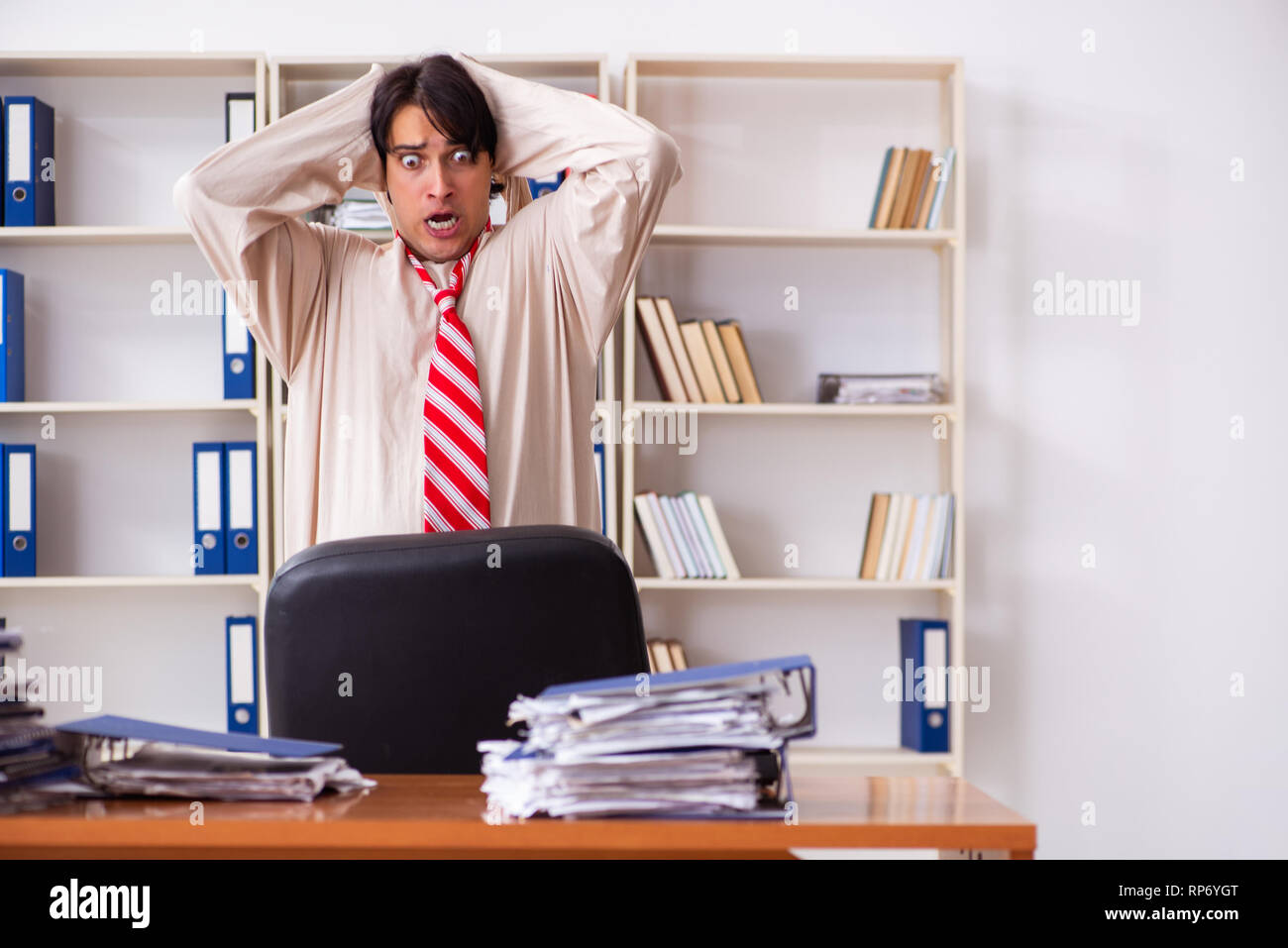 Crazy young man in straitjacket at the office Stock Photo - Alamy