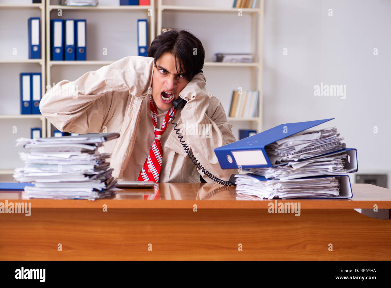 Crazy young man in straitjacket at the office Stock Photo - Alamy