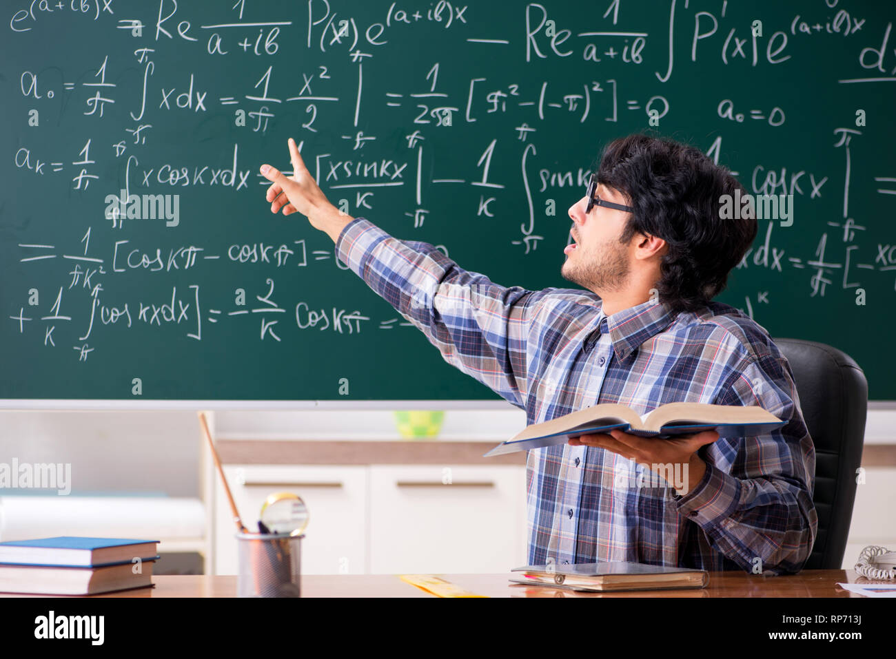Funny male math teacher in the classroom Stock Photo - Alamy