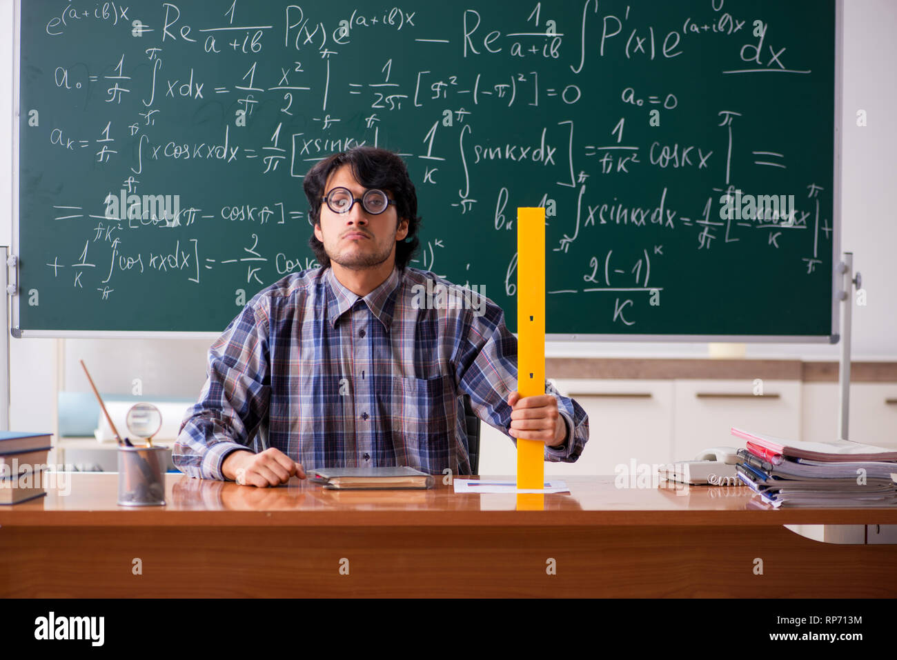Funny male math teacher in the classroom Stock Photo - Alamy