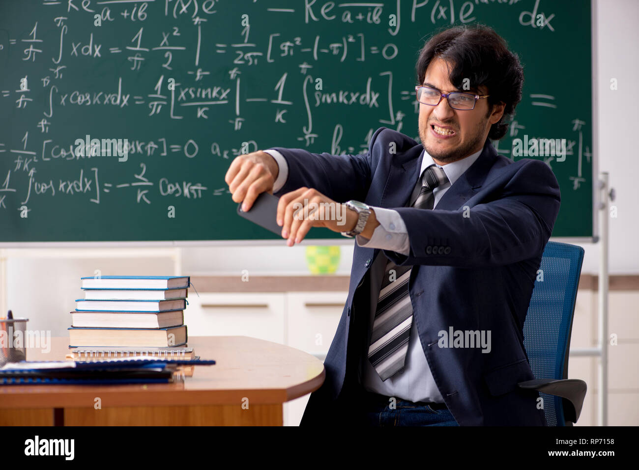 Young male math teacher in classroom Stock Photo - Alamy