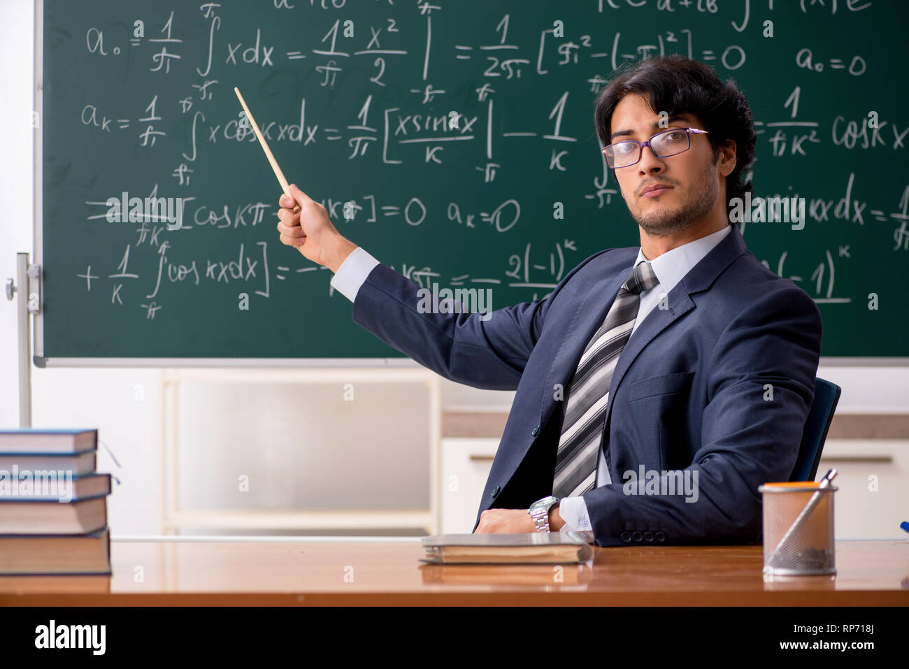 Young male math teacher in classroom Stock Photo - Alamy