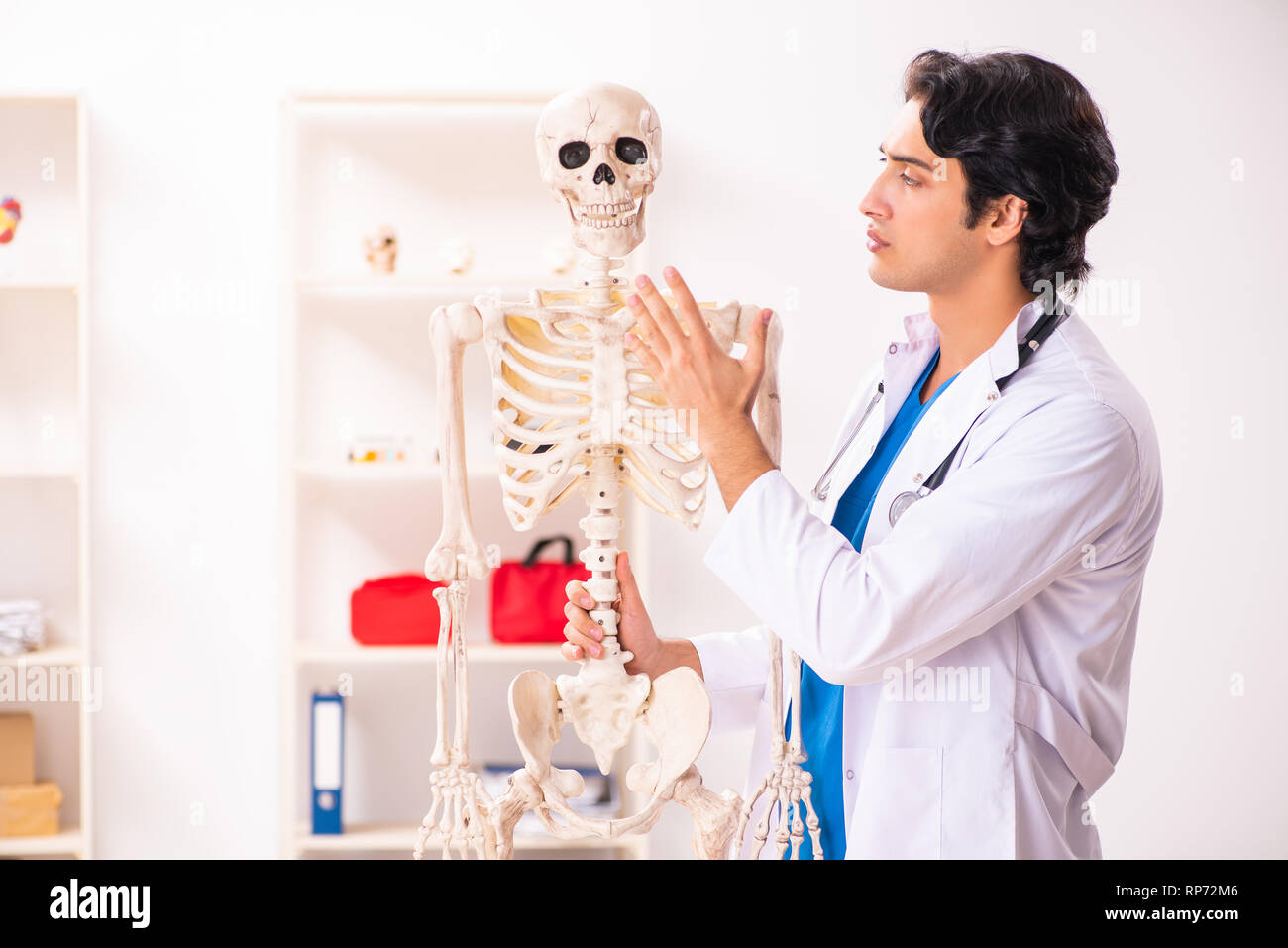 Young male doctor with skeleton Stock Photo - Alamy