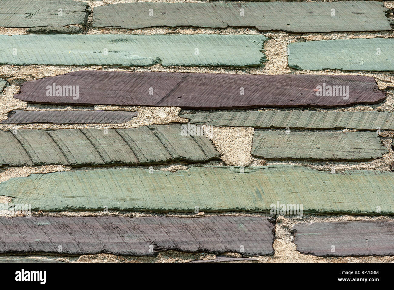 Detail of a colorful rough-cut slate stone wall Stock Photo - Alamy