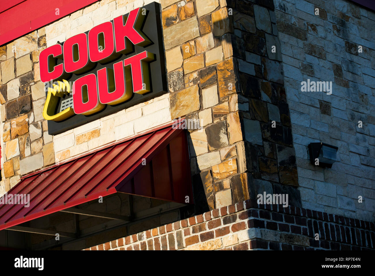 A logo sign outside of a Cook Out fast food restaurant location in ...