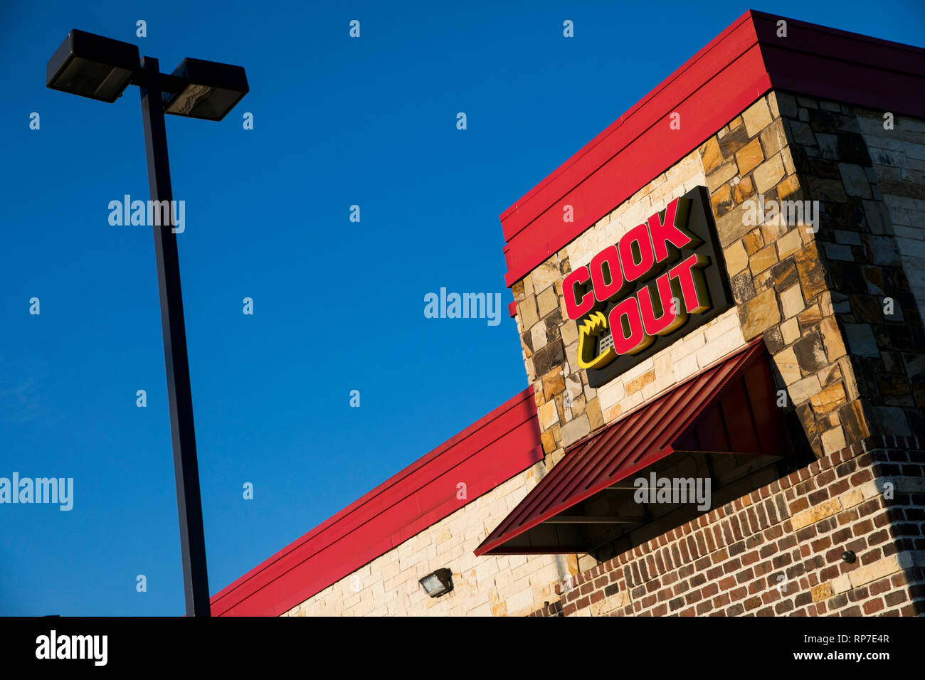 A logo sign outside of a Cook Out fast food restaurant location in ...