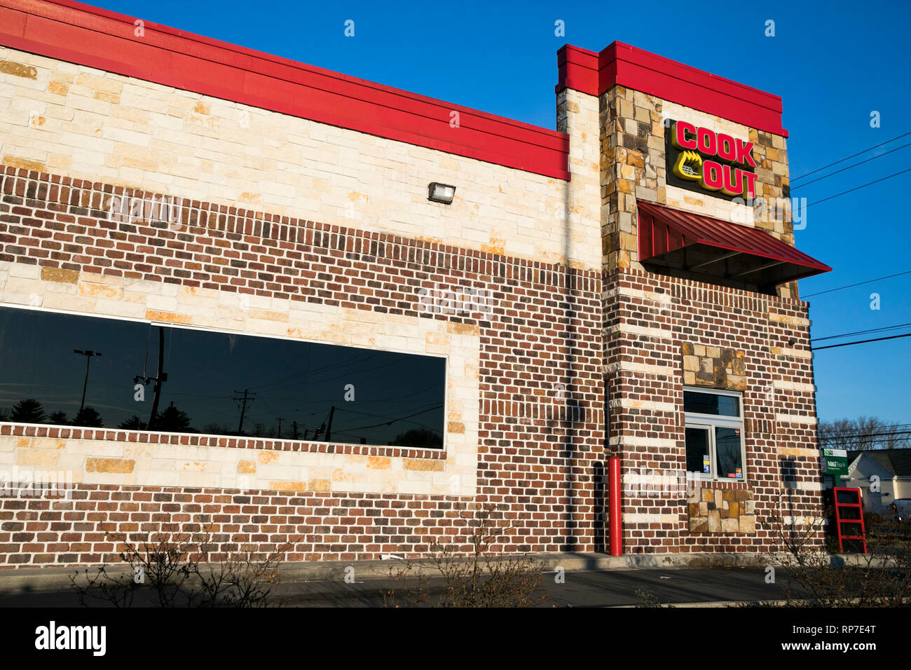 A logo sign outside of a Cook Out fast food restaurant location in ...