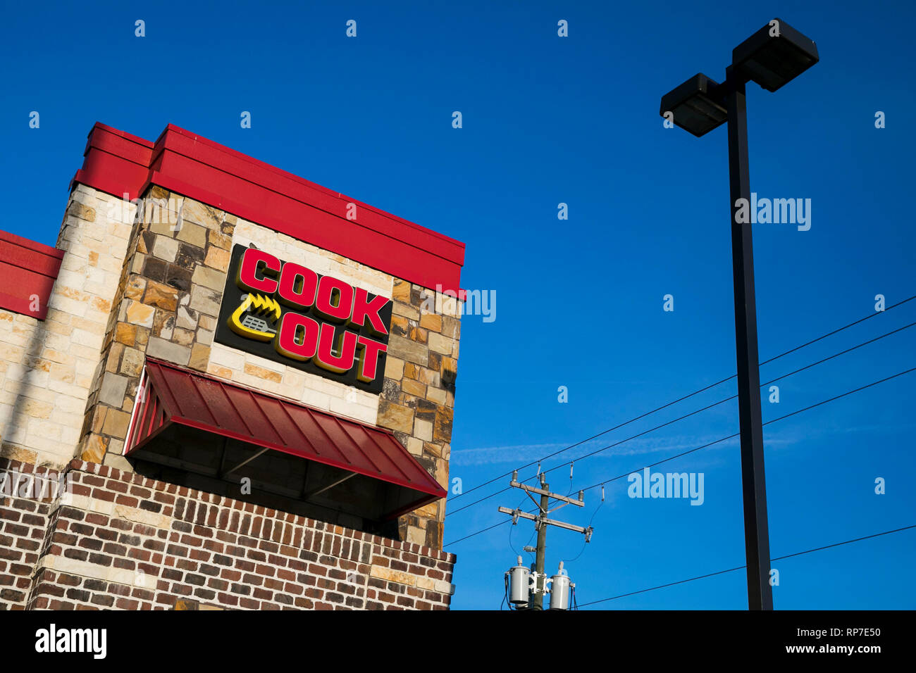A logo sign outside of a Cook Out fast food restaurant location in ...