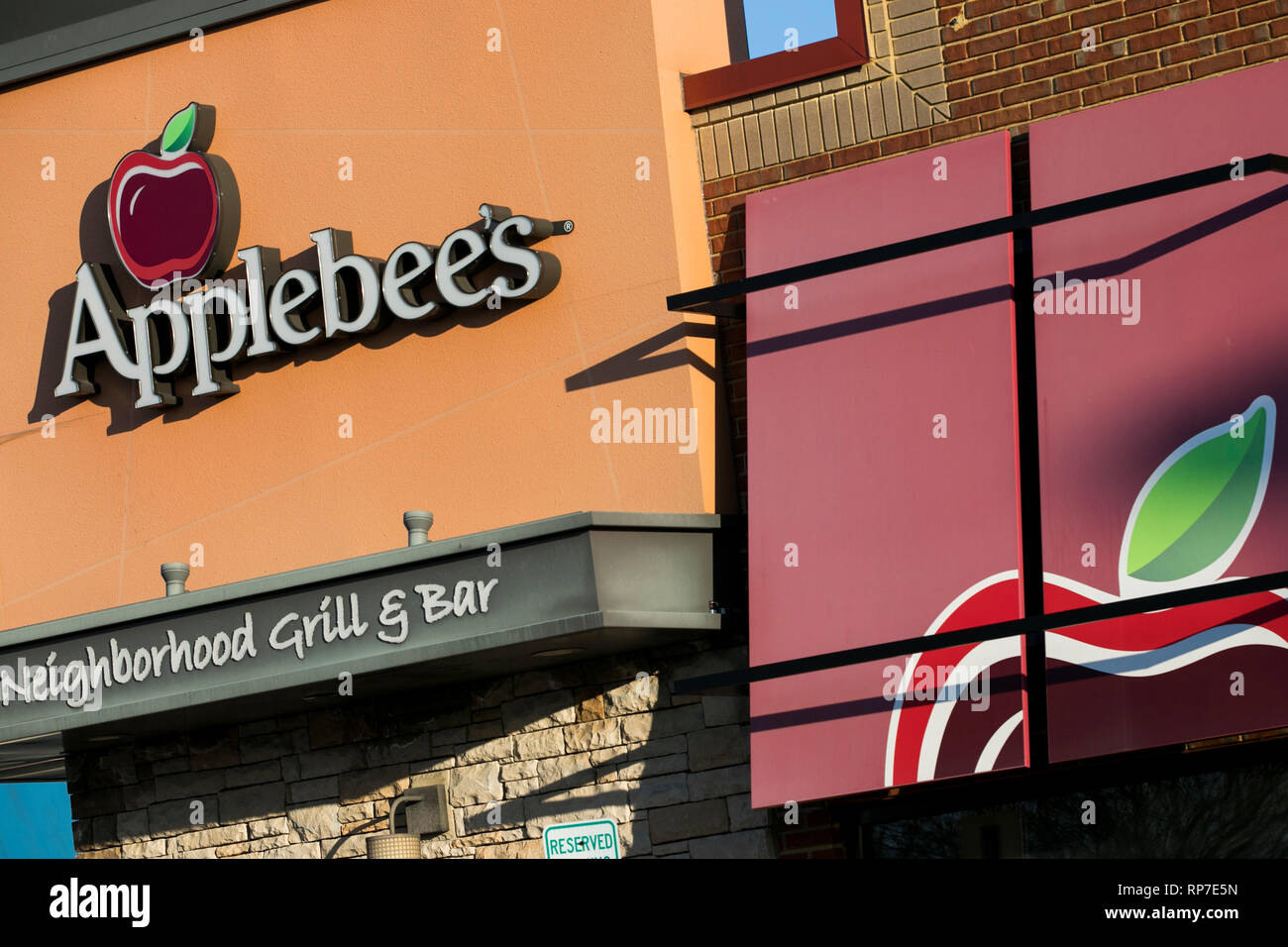 A logo sign outside of a Applebee's restaurant location in ...
