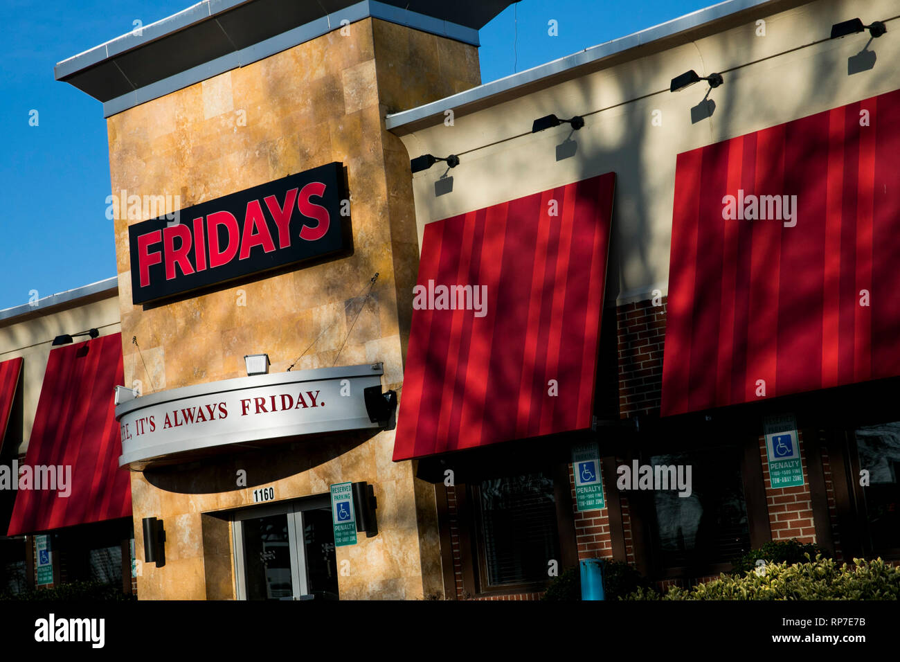 A logo sign outside of a TGI Fridays restaurant location in ...