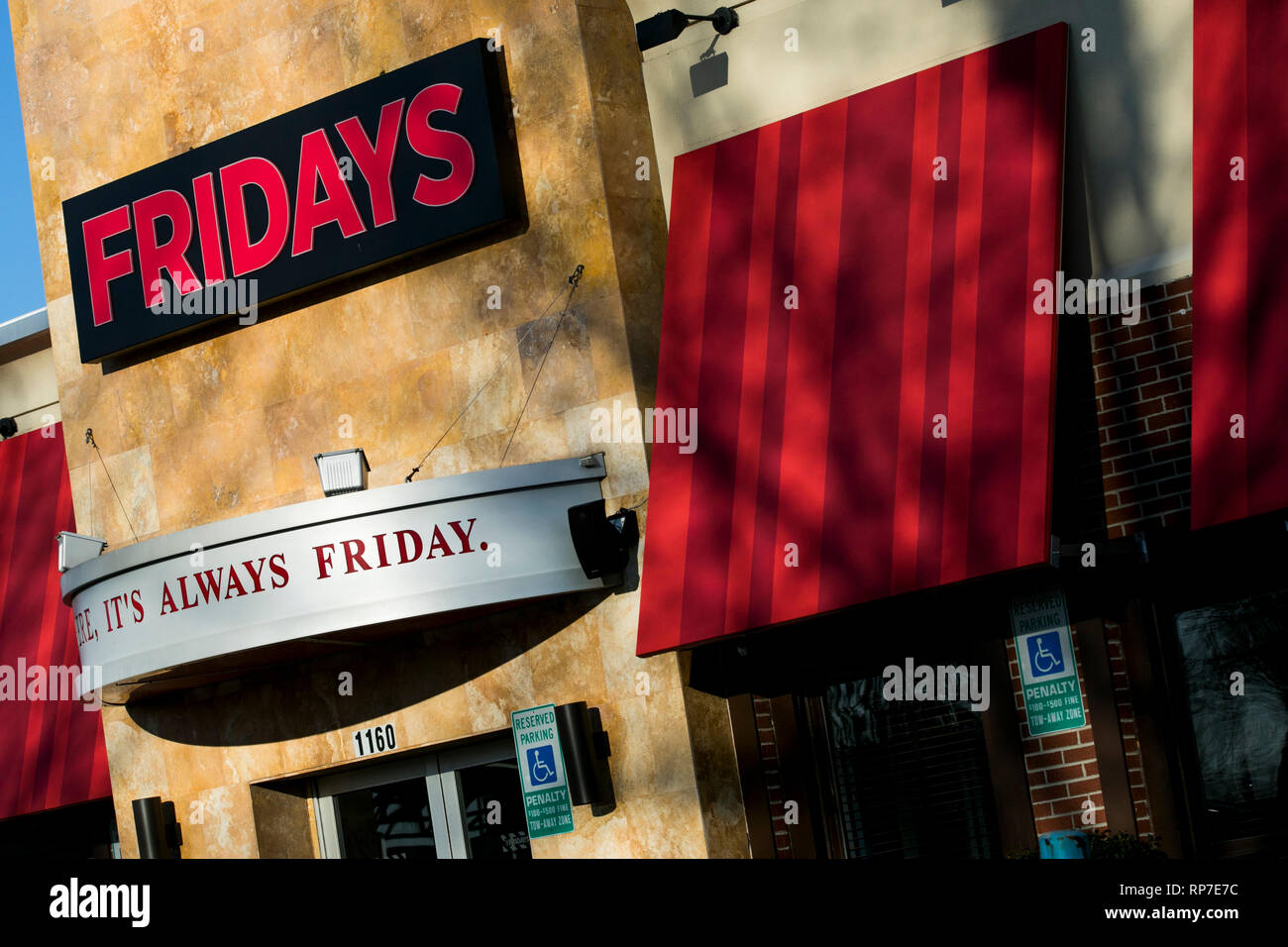 A logo sign outside of a TGI Fridays restaurant location in ...