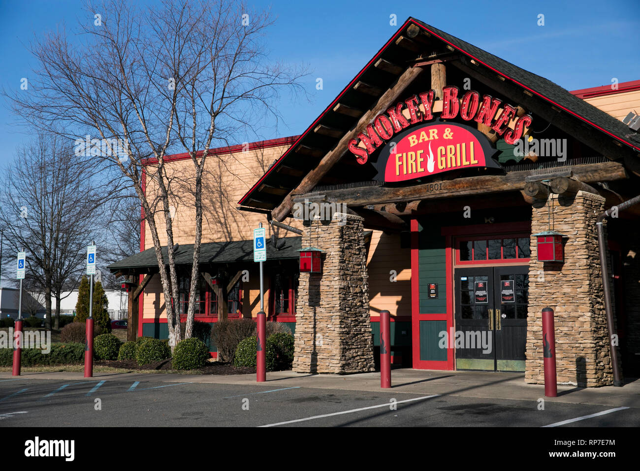 A logo sign outside of a Smokey Bones Bar and Fire Grill restaurant ...