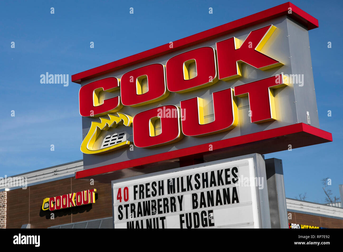 A logo sign outside of a Cook Out fast food restaurant location in ...