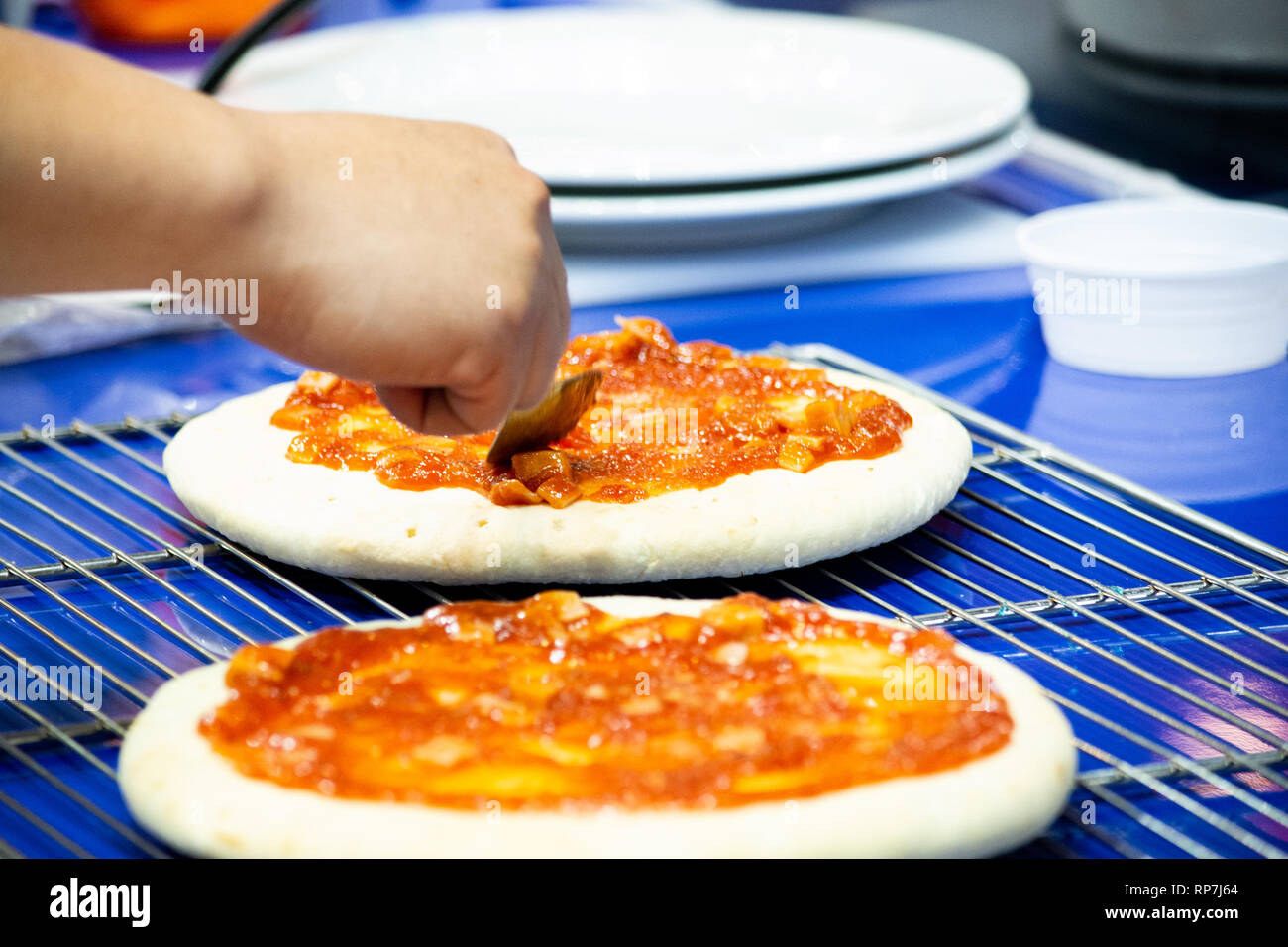 chef making pizza at kitchen, Chef spreading cheese toppings on pizza ...