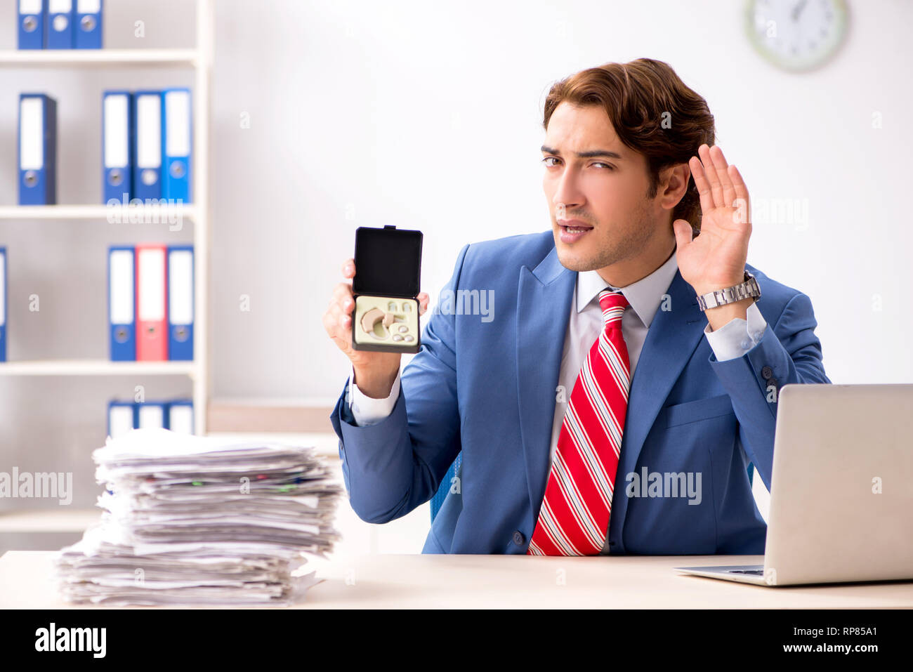 Deaf employee using hearing aid in office Stock Photo - Alamy