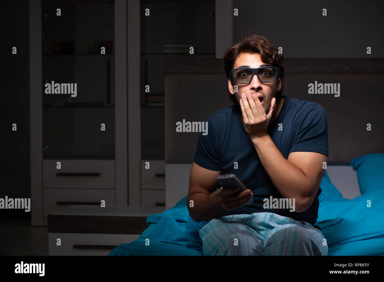 Man watching tv at night in bed Stock Photo - Alamy