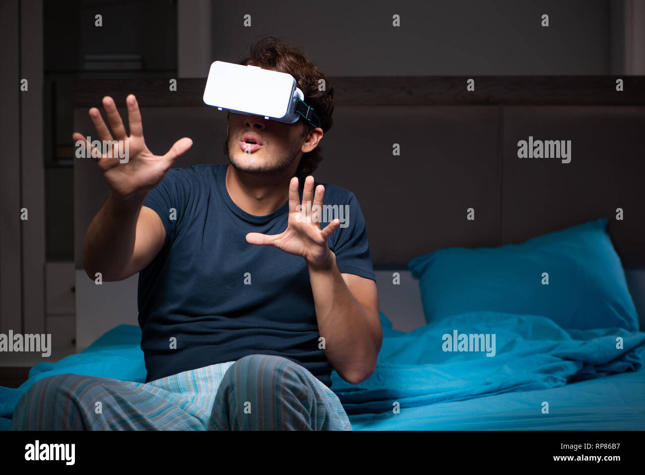 Young man playing computer games at night in bed Stock Photo - Alamy