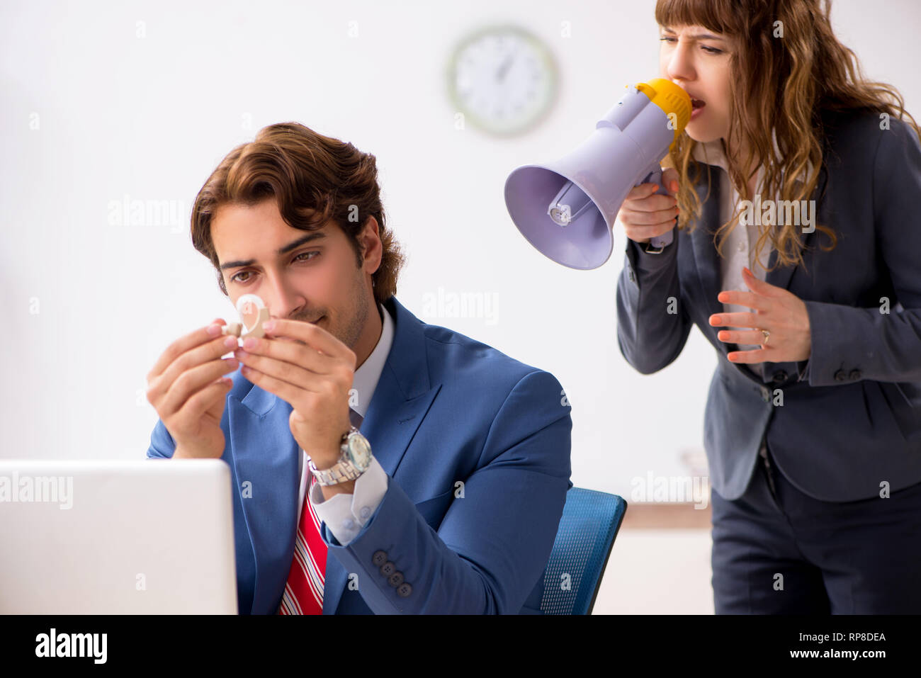 Deaf employee using hearing aid talking to boss Stock Photo - Alamy