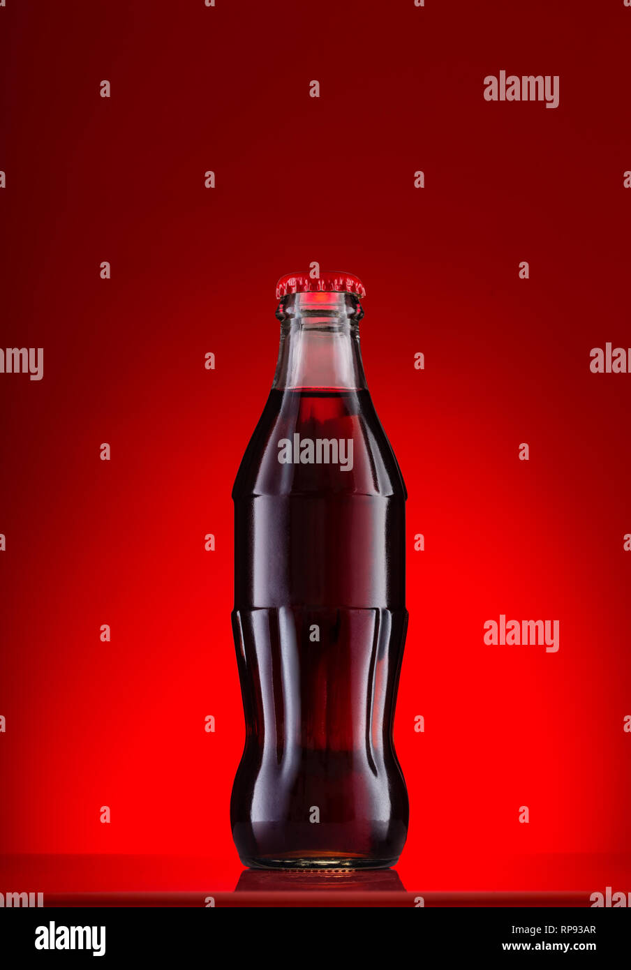 Bottle of cola on a red background Stock Photo - Alamy