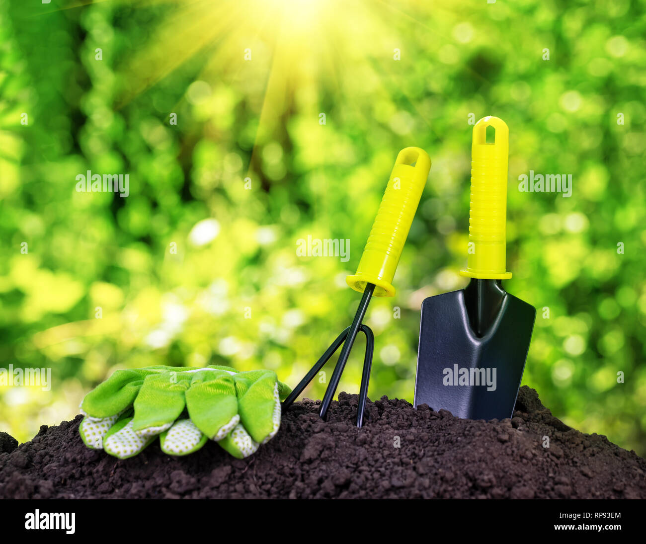 Garden tools rake trowel and gloves on pile of soil Stock Photo - Alamy