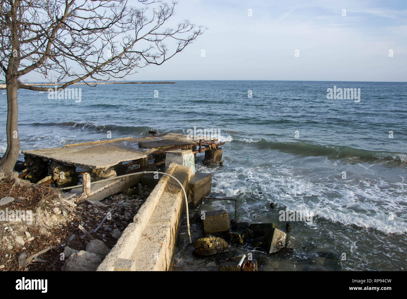 View of broken concrete pier in the sea, coastal destruction with ...