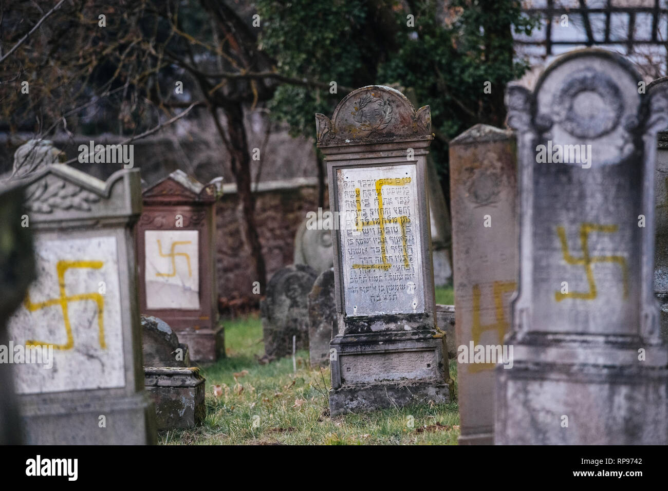 Front view of vandalised graves with nazi symbols in yellow spray ...
