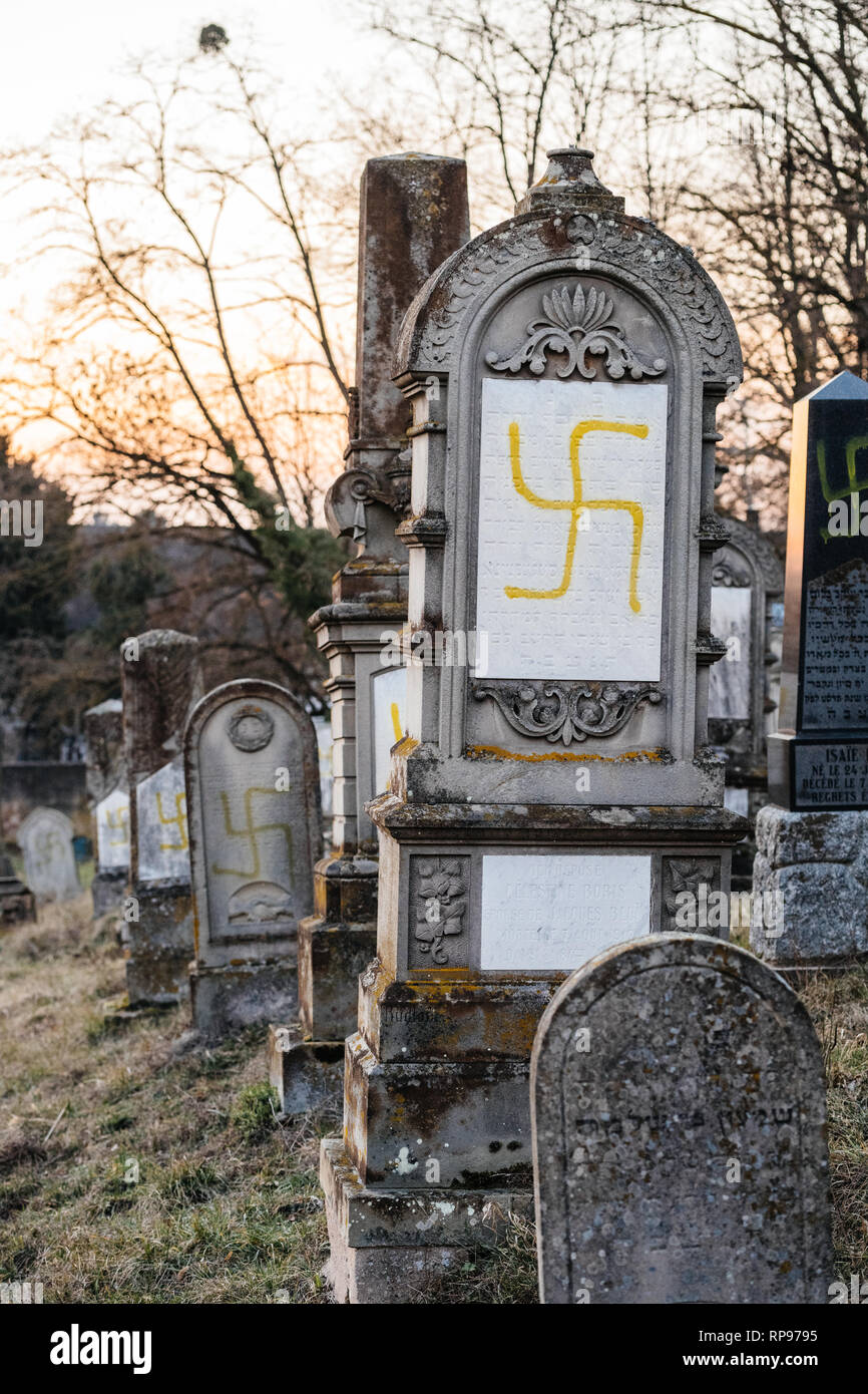Perspective view over vandalised graves with nazi symbols in yellow ...