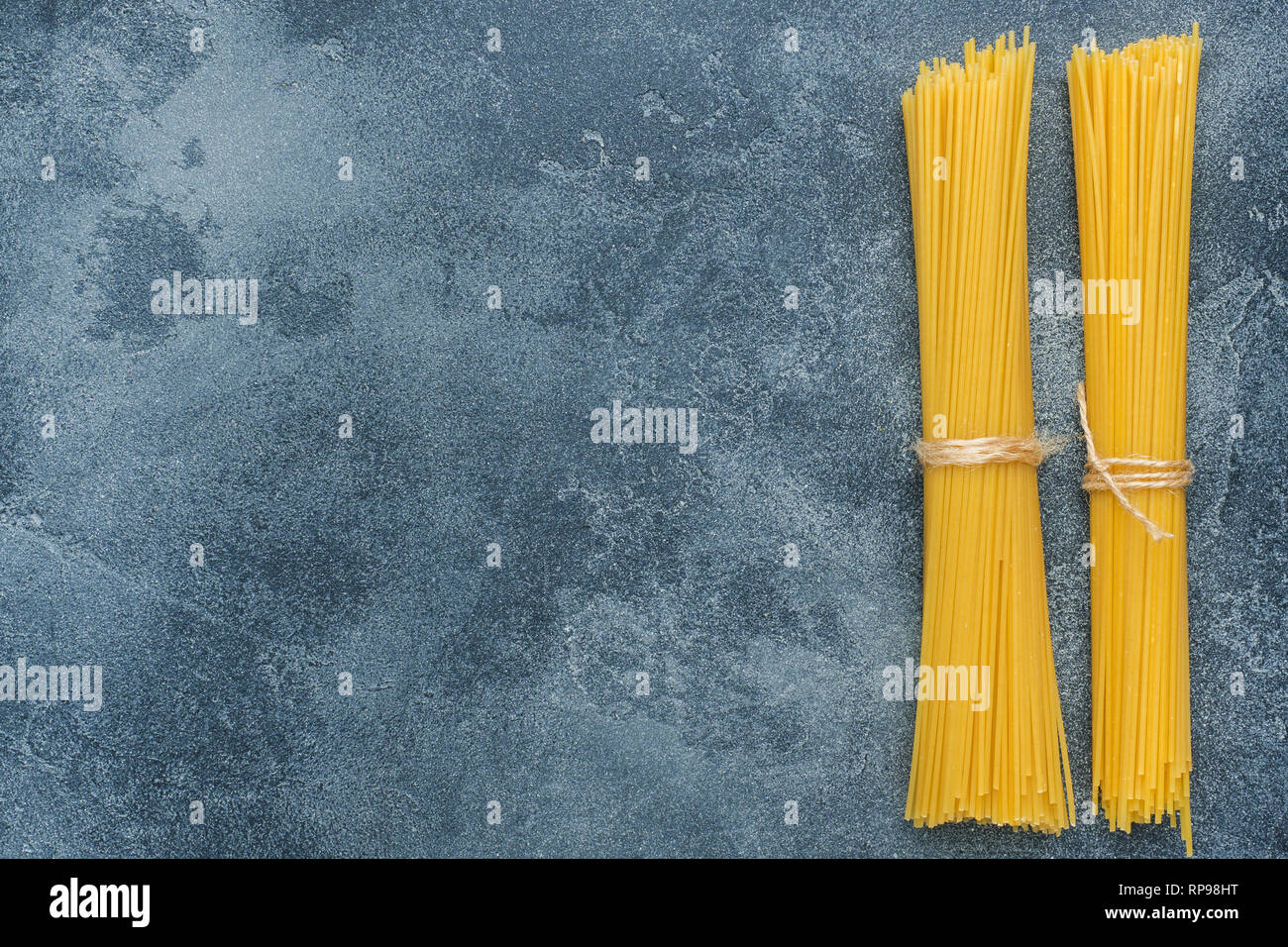 Raw macaroni, spaghetti on a dark stone table with copy space. Homemade ...