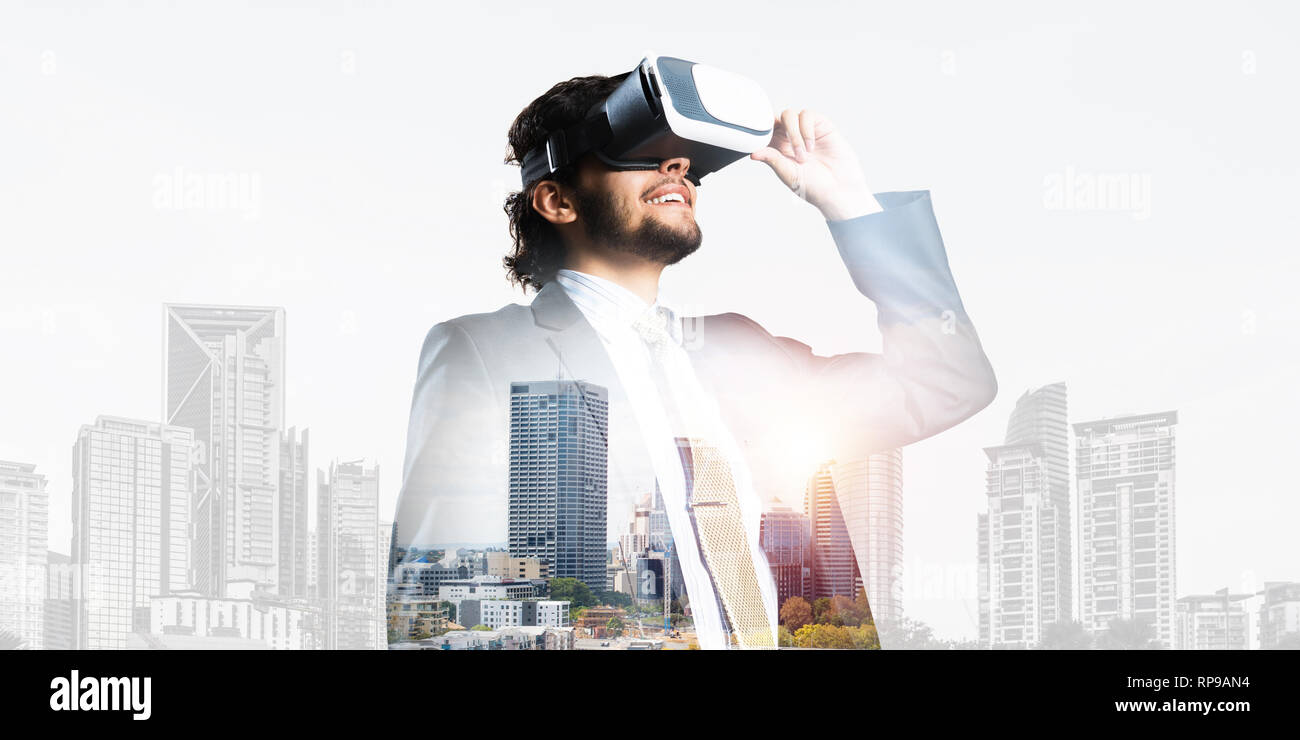 Handsome businessman in rays of sunrise experiencing impressive virtual ...