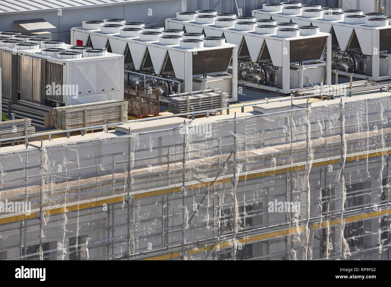 Air conditioner compressors on a building rooftop under construction ...
