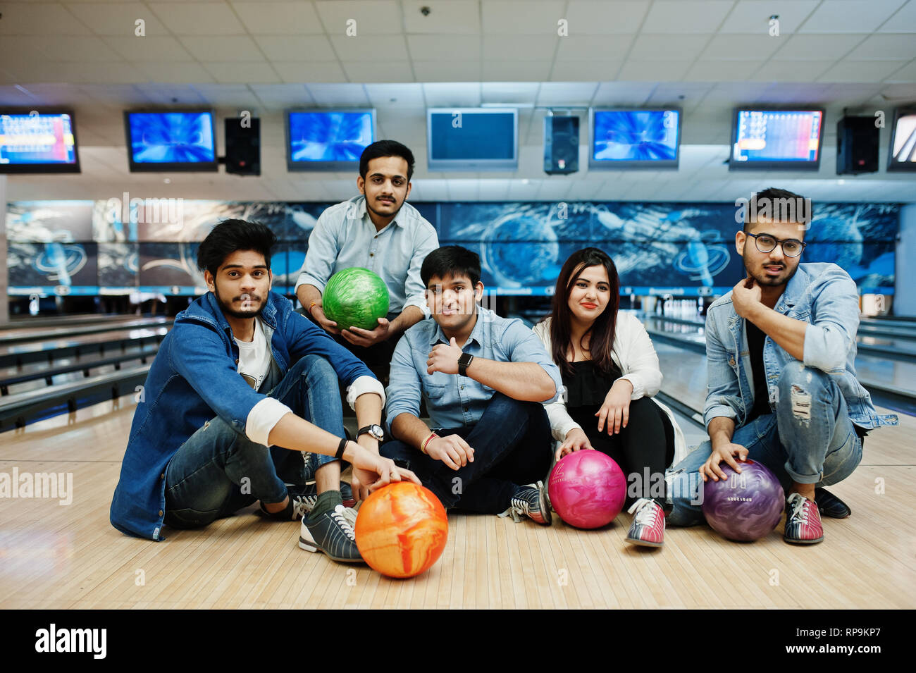 Group of five south asian peoples having rest and fun at bowling club ...