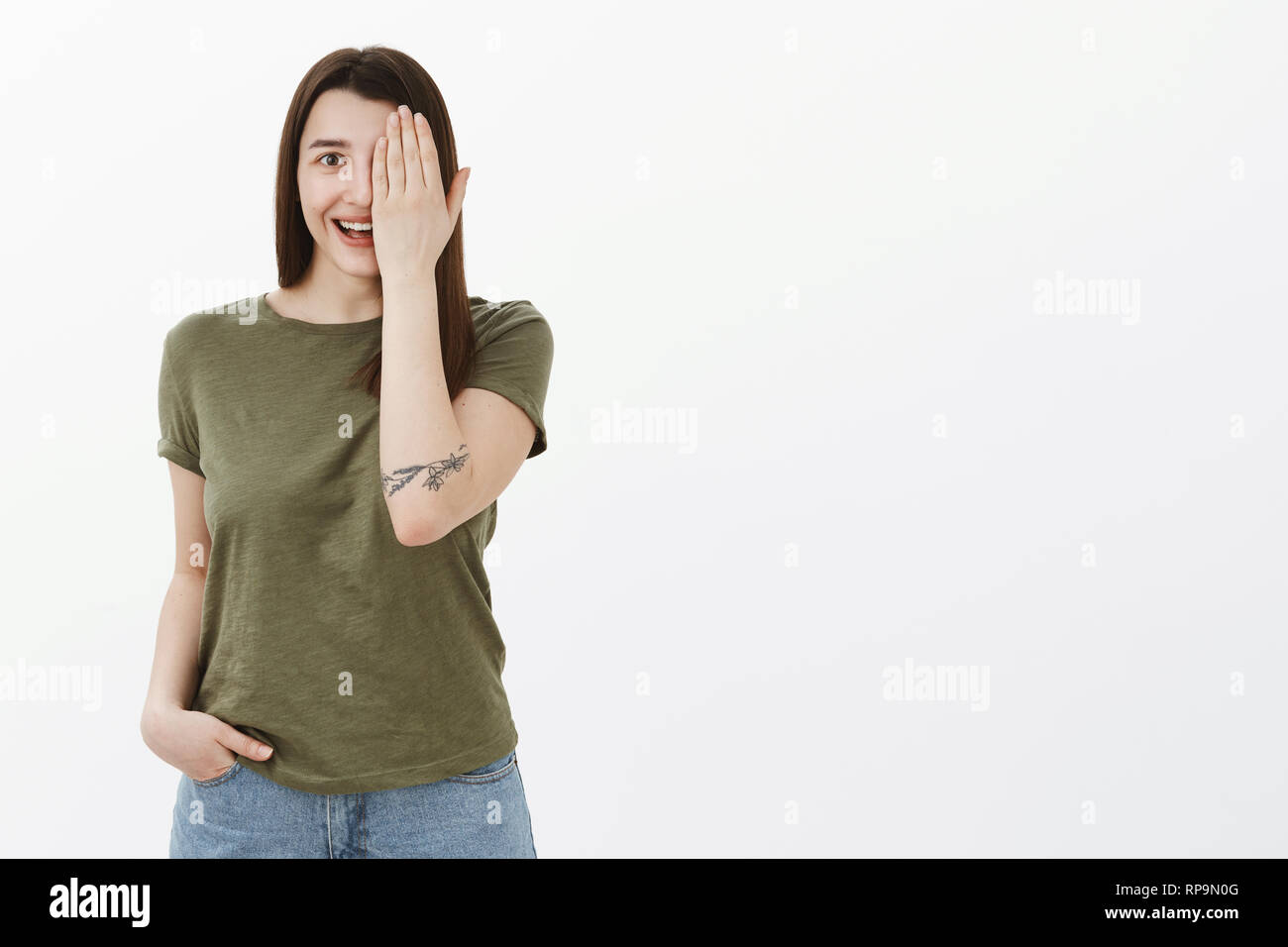 Amazed and impressed charismatic young woman with tattoo cover half of ...