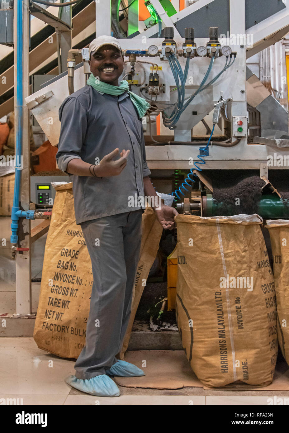 A worker at work in the Lockhart tea factory using new macinery smiling ...