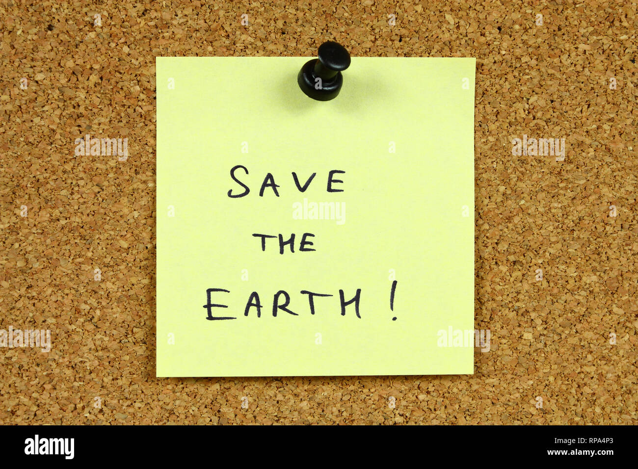 Yellow sticky note pinned to an office notice board. Save the earth ...
