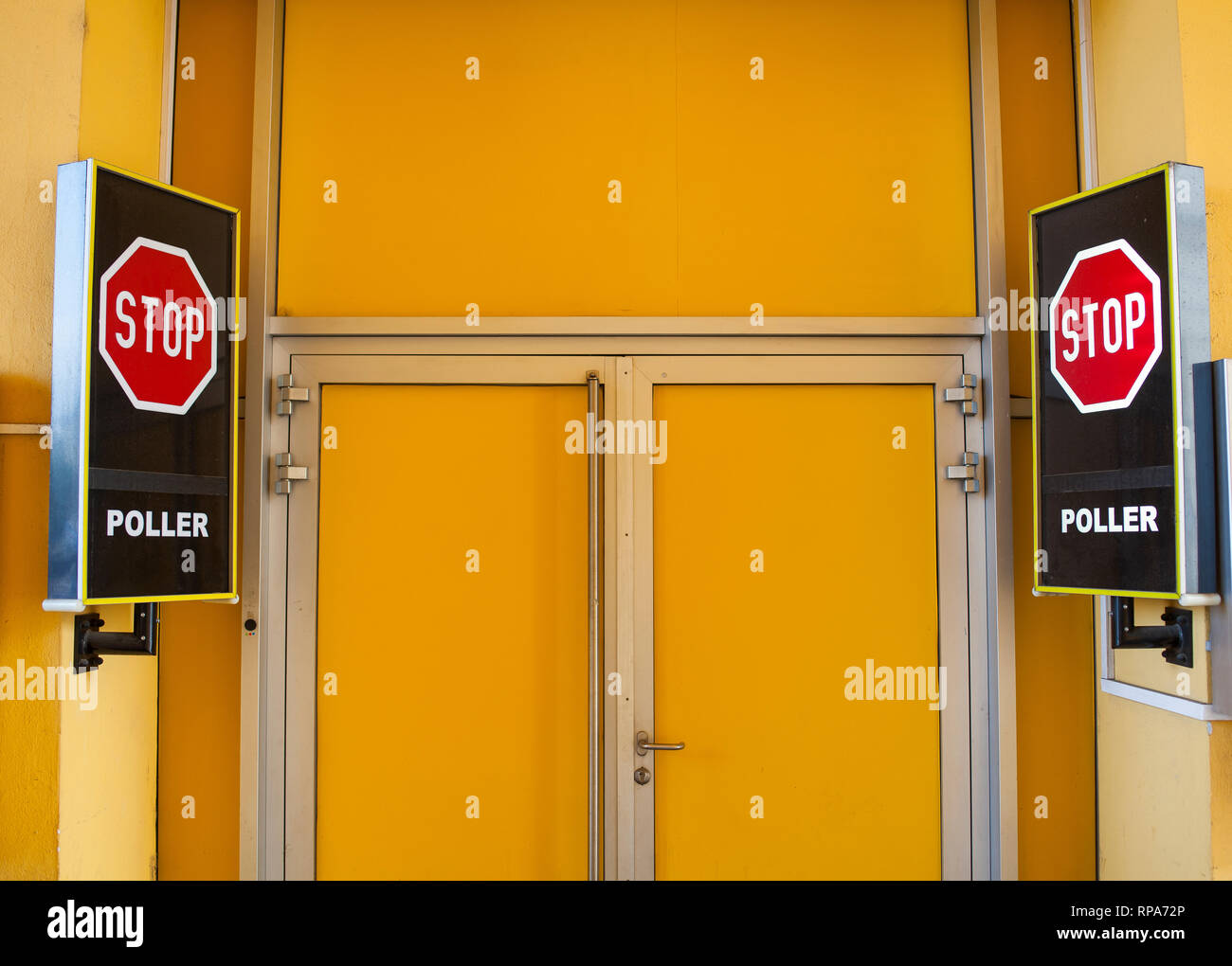 Stop signboards next to the closed yellow door Stock Photo - Alamy