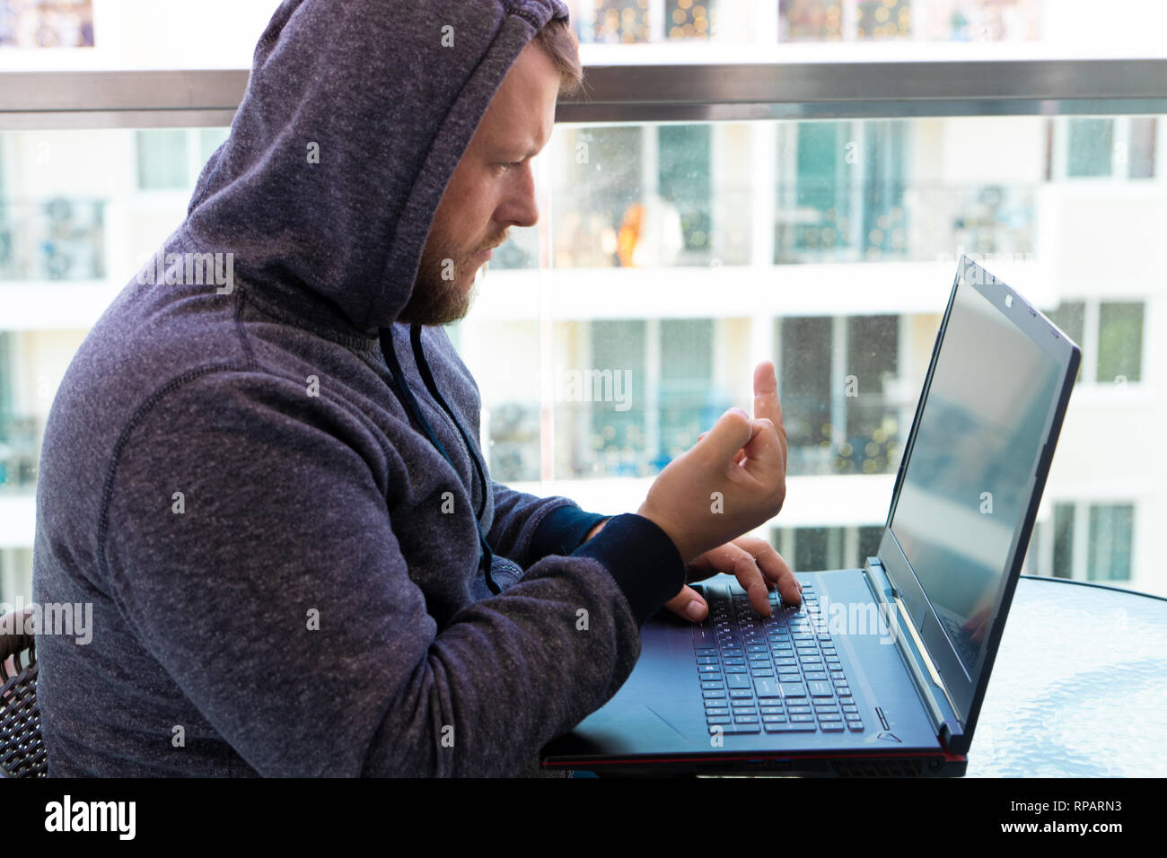 Cybercrime, hacking and technology concept - male hacker writing code ...