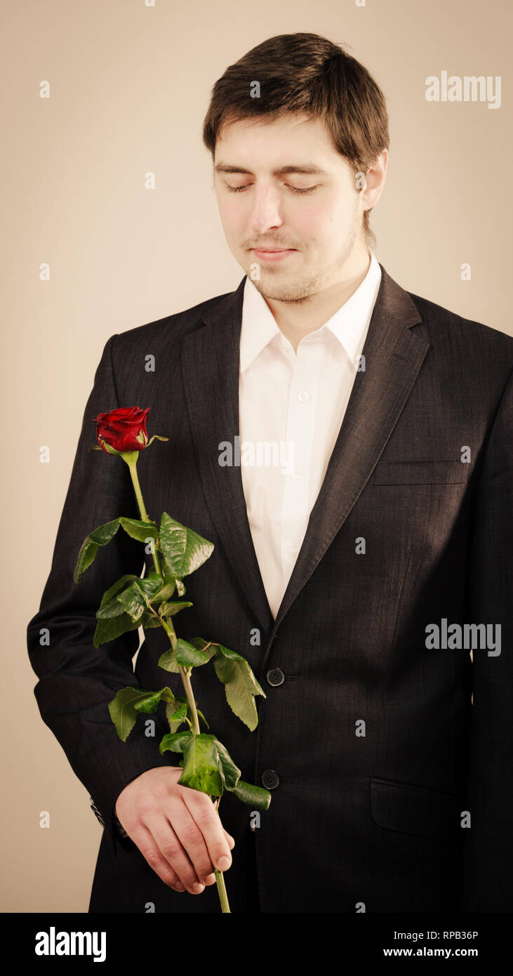 Smart clothing for guys. Elegant young man with red rose. Handsome boy ...
