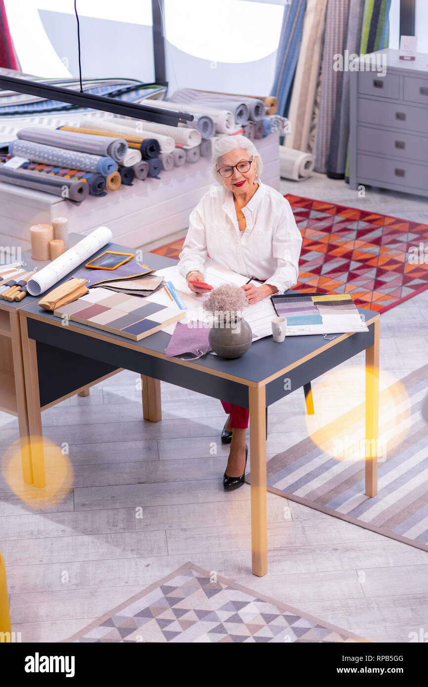 Designer working on sketch sitting at engulfed with textile desk Stock ...
