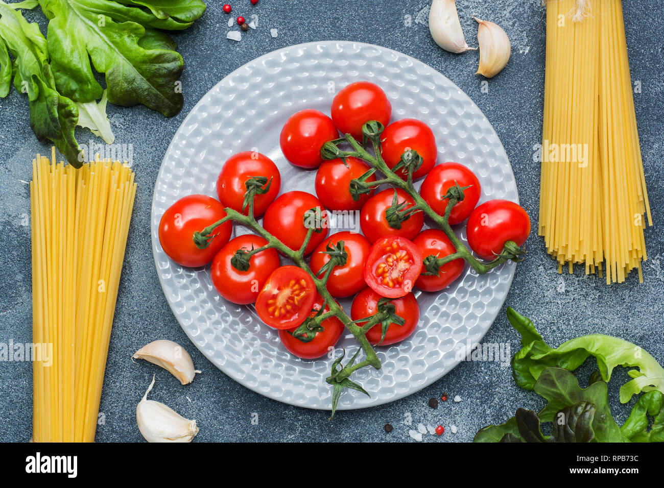Raw Italian pasta spaghetti and cooking ingredients cherry tomatoes ...
