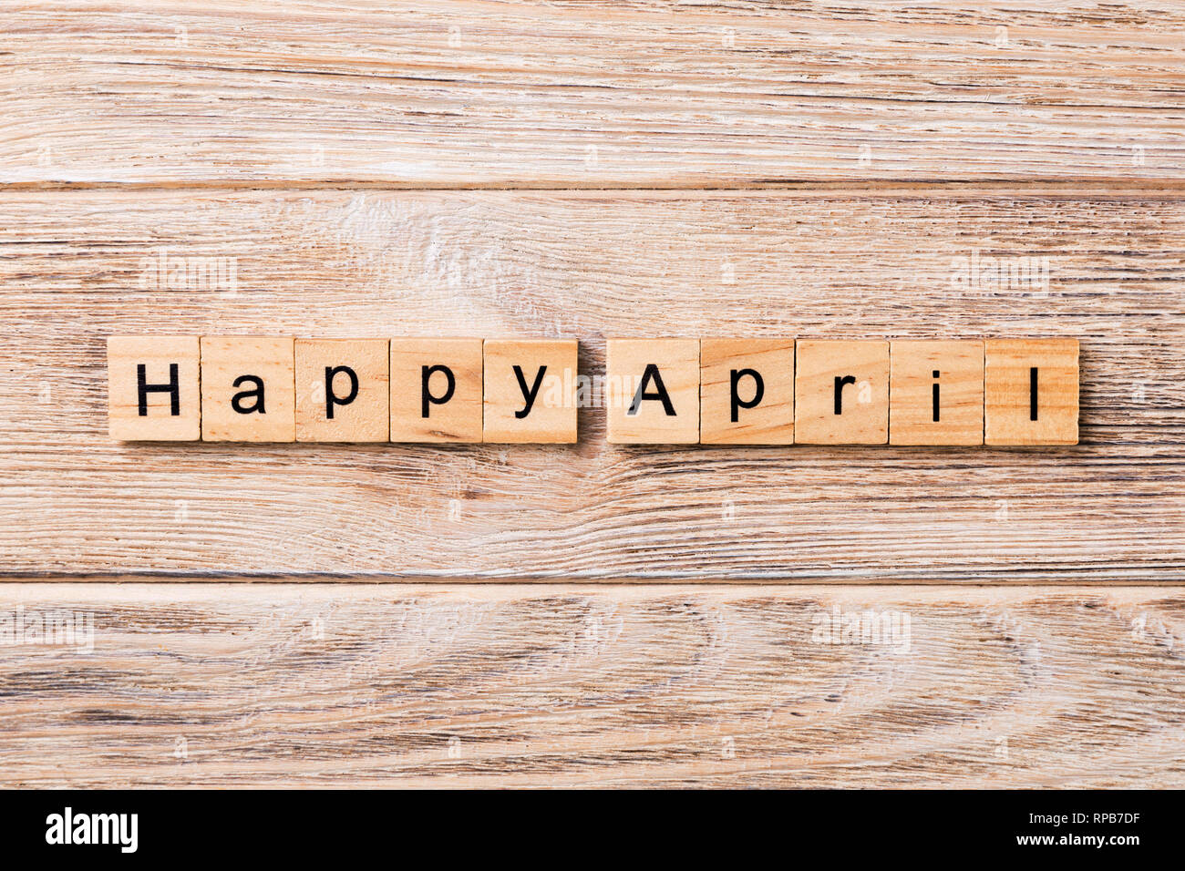 Happy april word written on wood block. Happy april text on table ...
