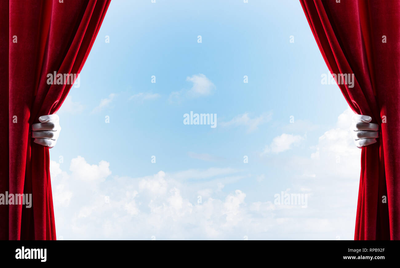 Cloudy landscape behind red curtain and hand holding it Stock Photo - Alamy