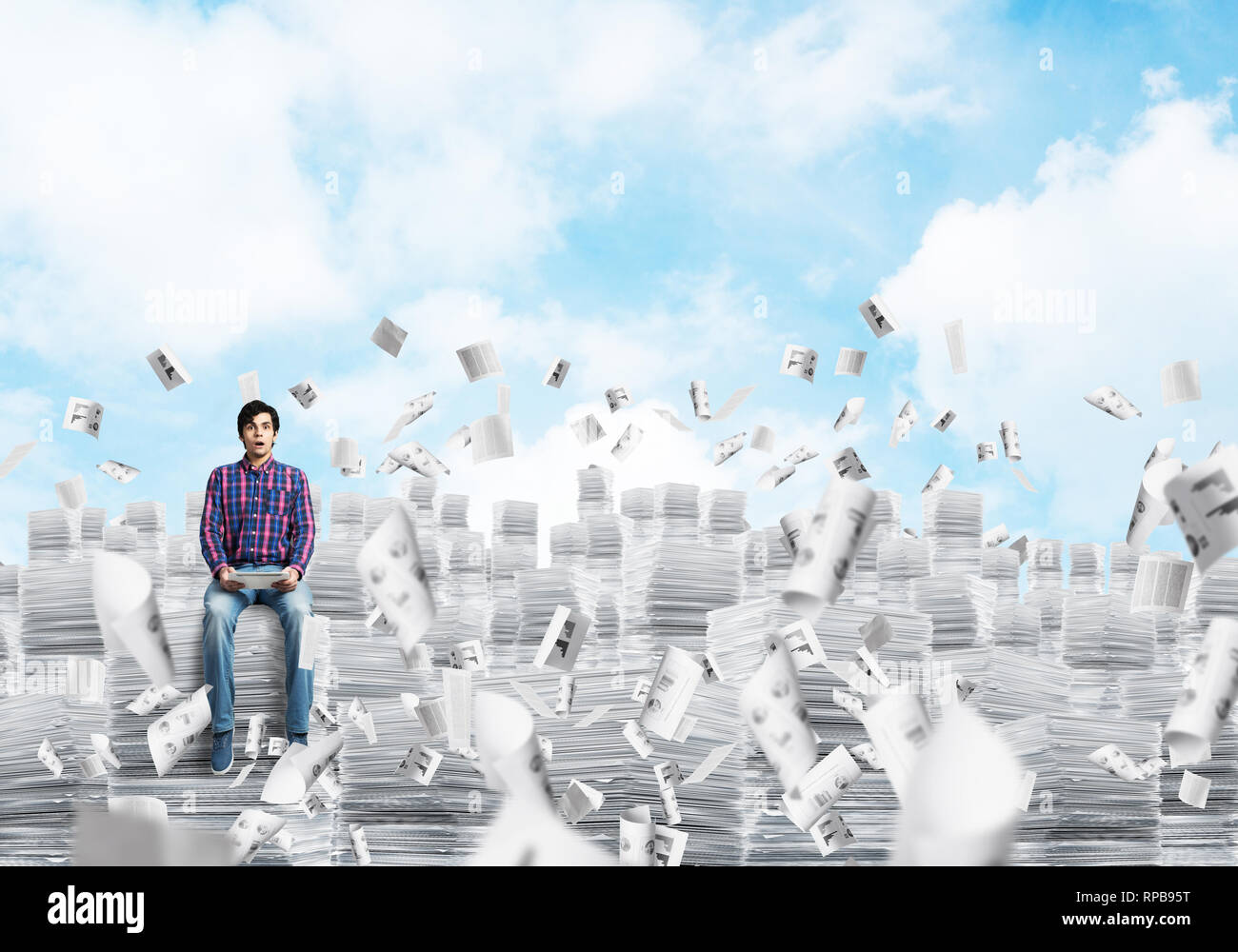 Attractive man sitting on pile of paper documents Stock Photo - Alamy