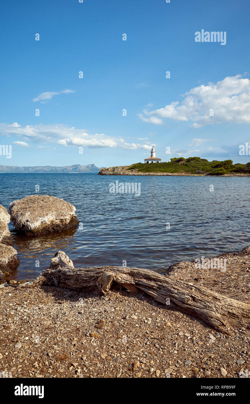 Beach with Alcanada Lighthouse (Faro de Alcanada) in distance, Mallorca ...
