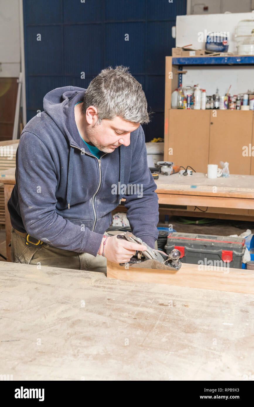 Worker man concept. Male carpenter working in his carpentry workshop ...