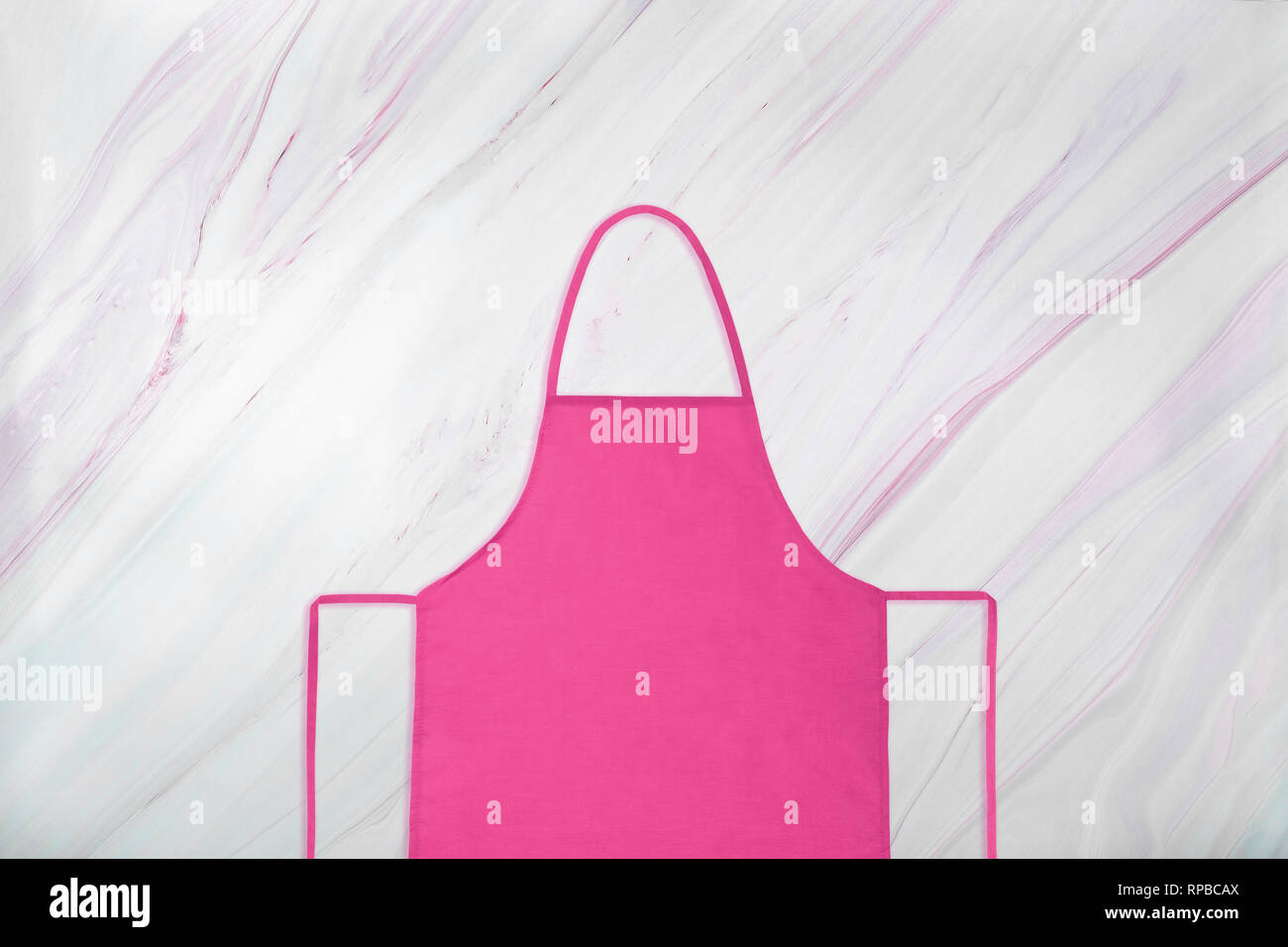 Closeup of pink kitchen apron on marble texture with natural pattern as ...