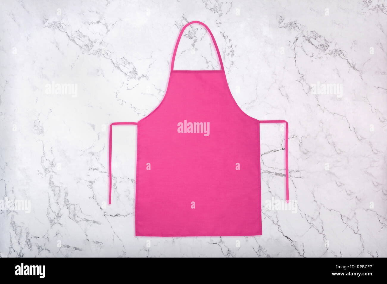 Pink kitchen apron on white marble texture with natural pattern. Blank ...